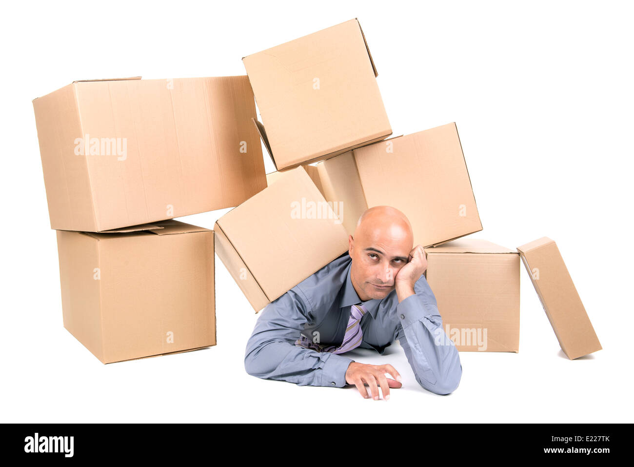 Bored businessman under a pile of cardboard boxes Stock Photo - Alamy