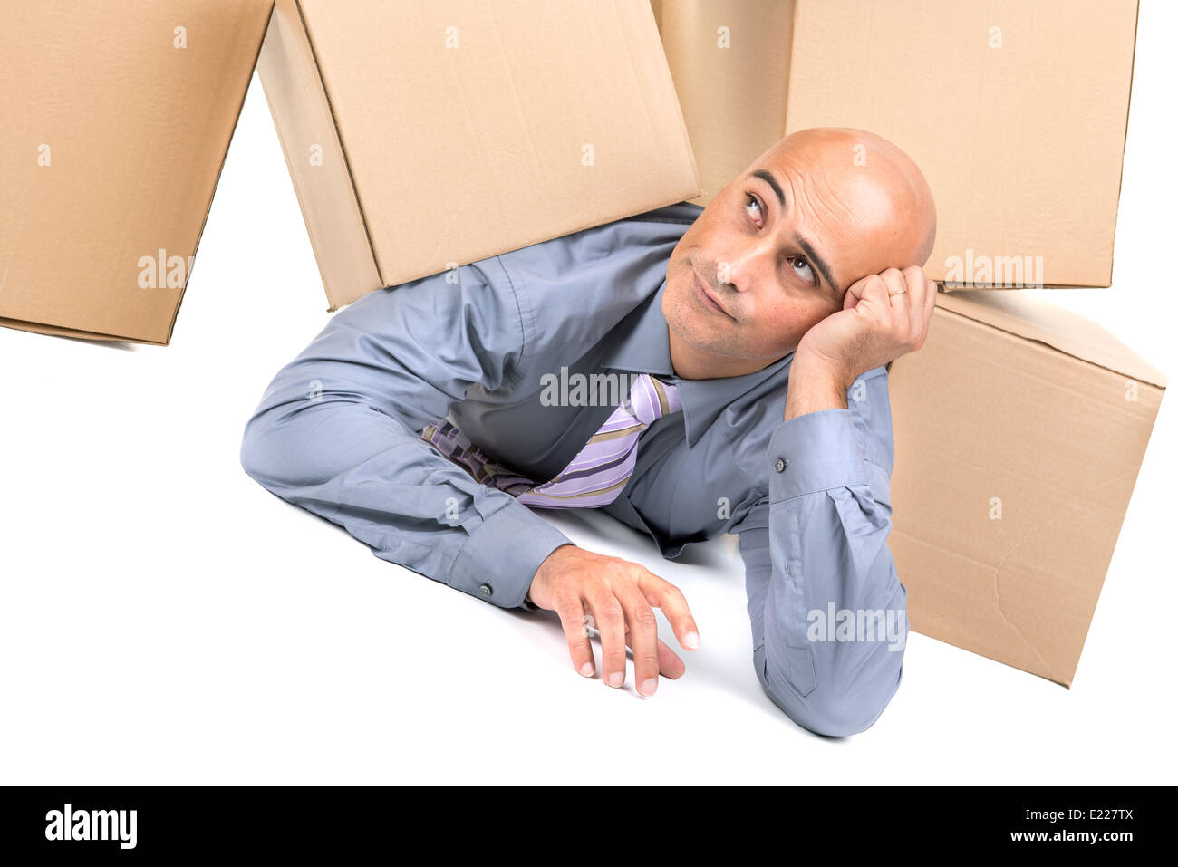 Bored businessman under a pile of cardboard boxes Stock Photo - Alamy