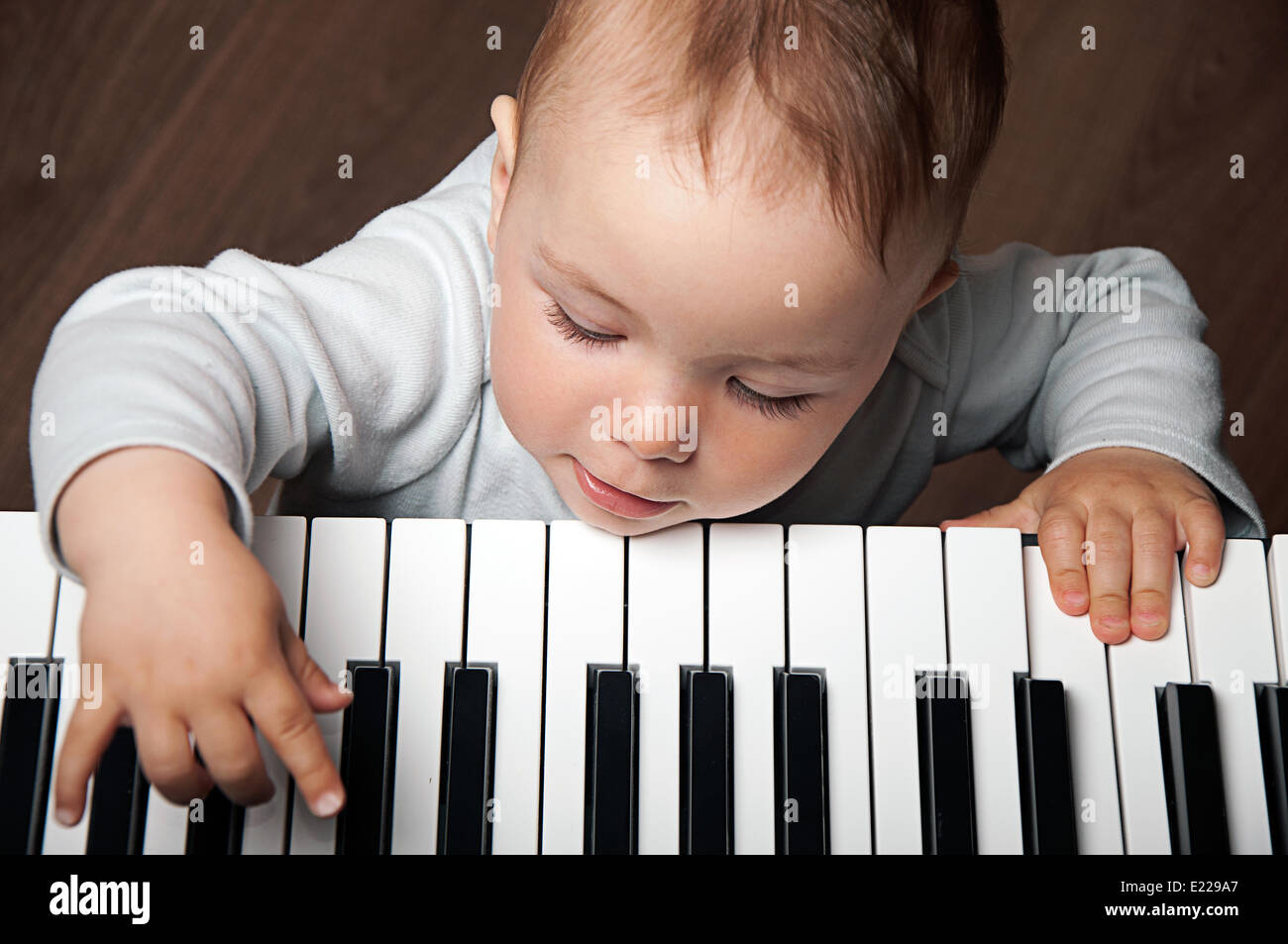baby play music on piano keyboard Stock Photo - Alamy