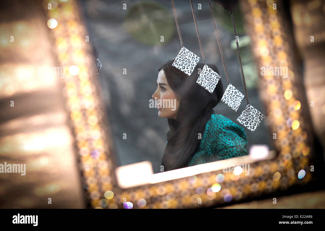 Tehran, Iran. 12th June, 2014. A visitor is reflected in a mirror as ...