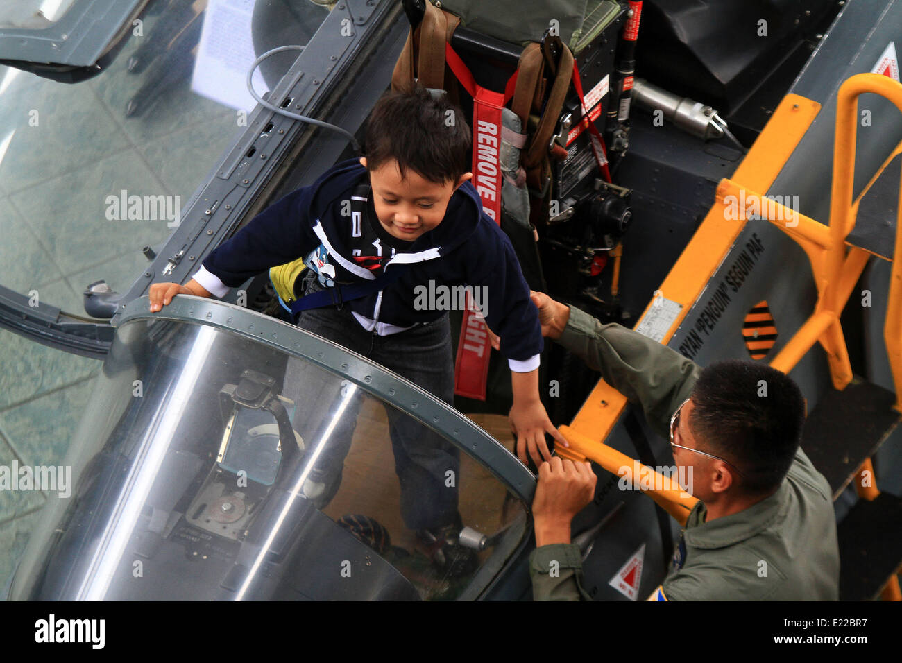 Pasay City, Philippines. 13th June, 2014. A pilot assists a boy inside ...