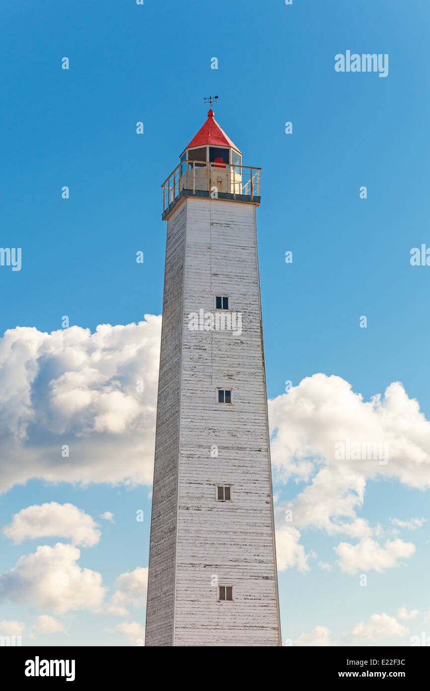 Tall gray lighthouse tower with red light and top Stock Photo - Alamy
