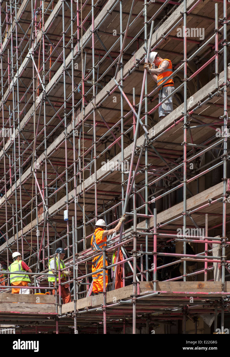 Men constructing scaffolding wearing hi viz Manchester City Centre ...
