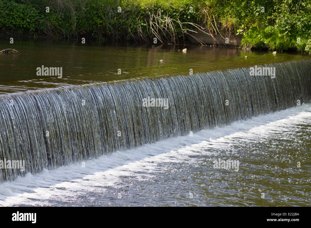 weir water cascades down stream Stock Photo - Alamy