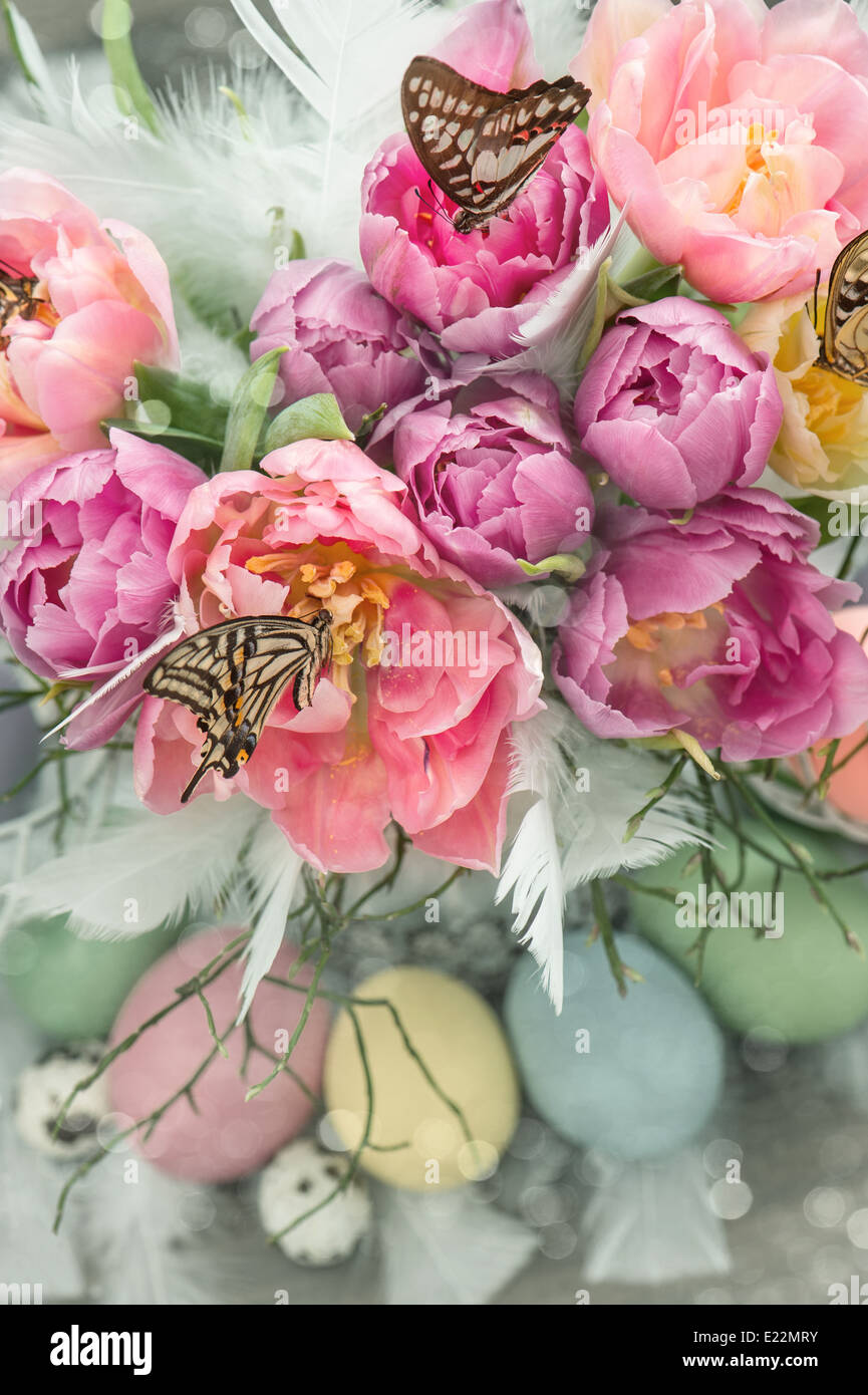easter decoration with pink tulip flowers, butterflies and colored eggs ...