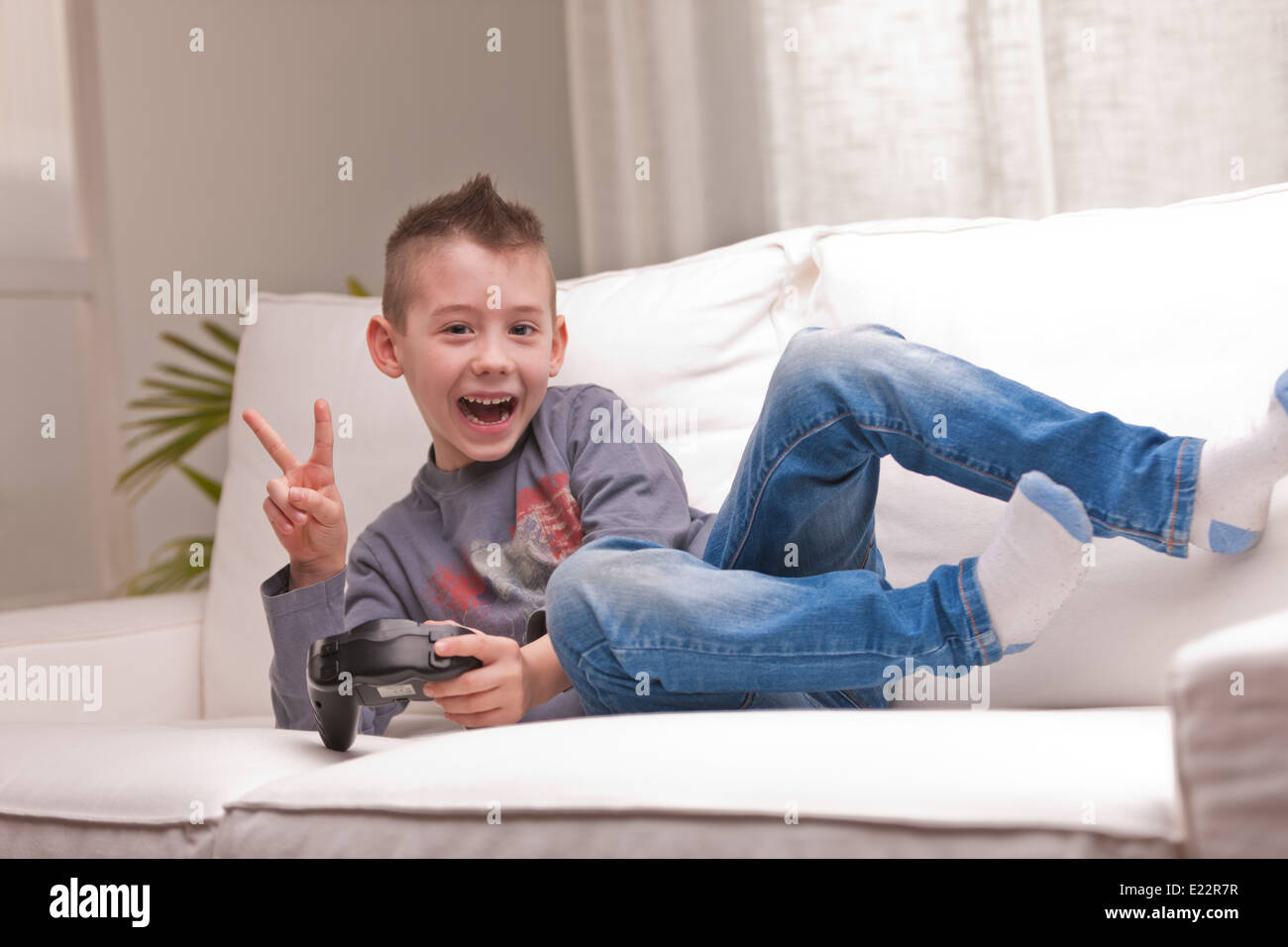 Kid having fun with video games in a brighly lit living room Stock ...