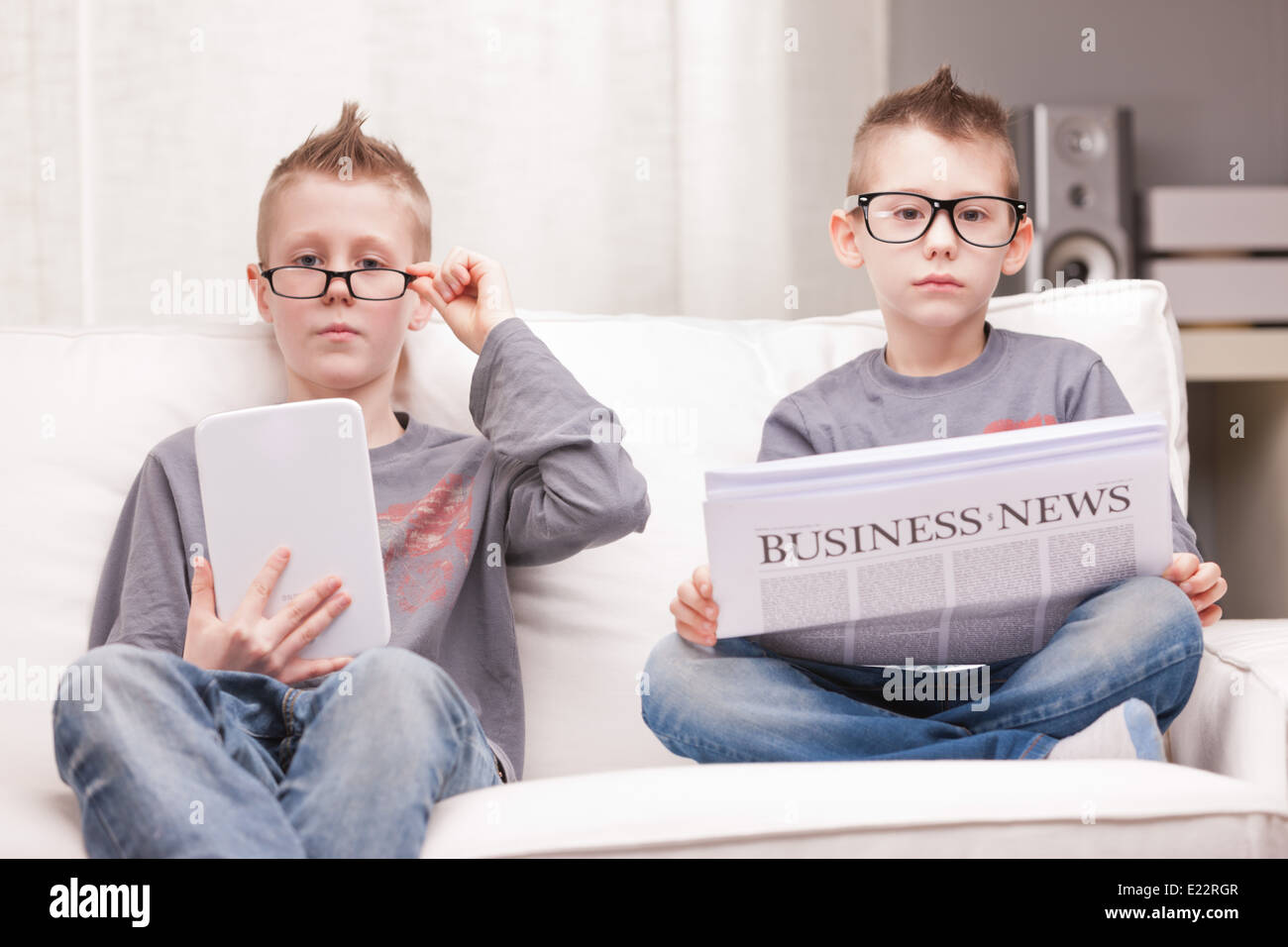 two little boys reading on newspapers or digital devices Stock Photo ...