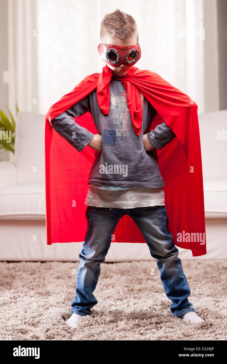 a little kid playing as a red cloak serious superhero Stock Photo - Alamy