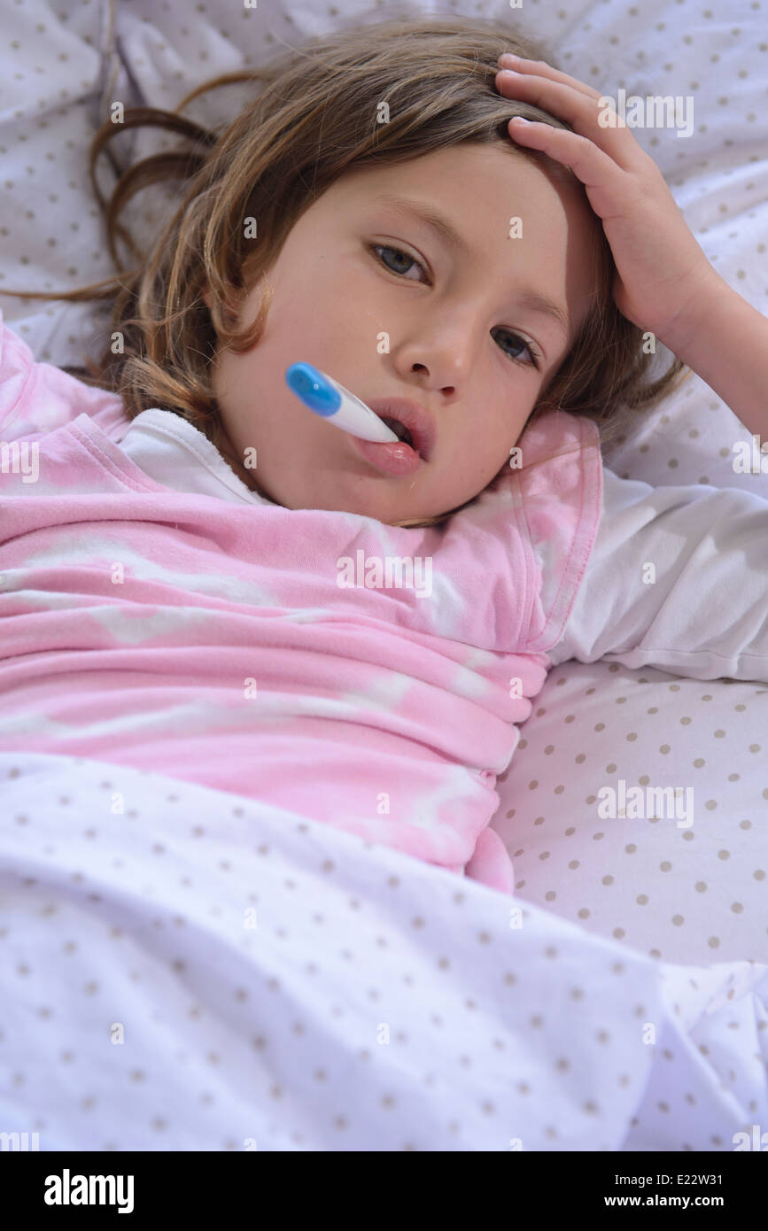 Sick child with fever in bed Stock Photo - Alamy