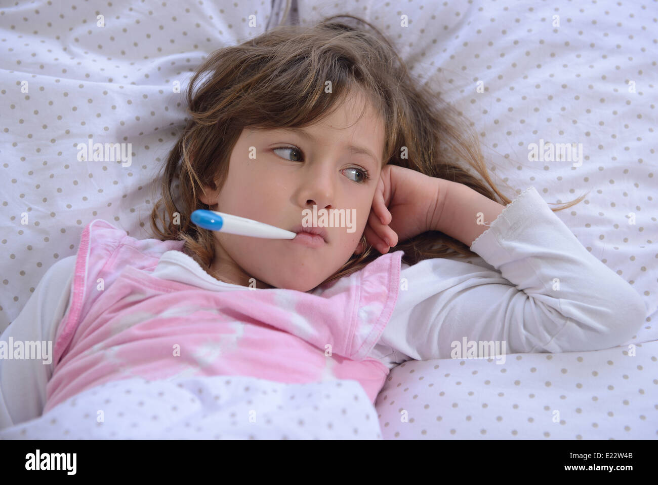 Sick child with fever in bed Stock Photo - Alamy