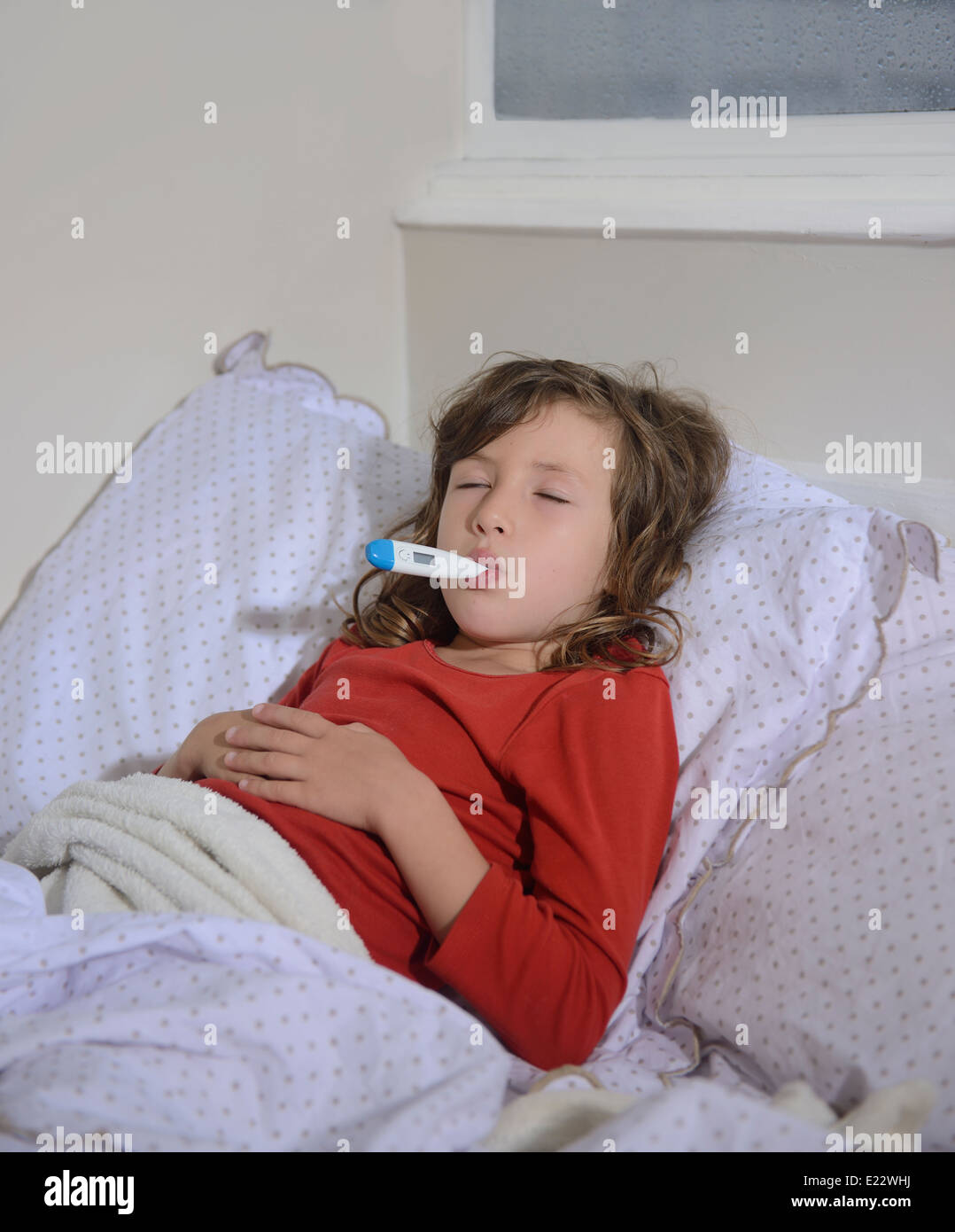 Sick with fever in bed: Child taking temperature Stock Photo - Alamy