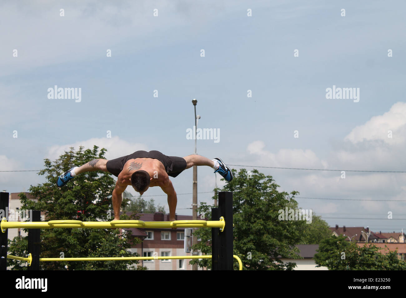 healthy young man stretch legs in split on bar Stock Photo - Alamy