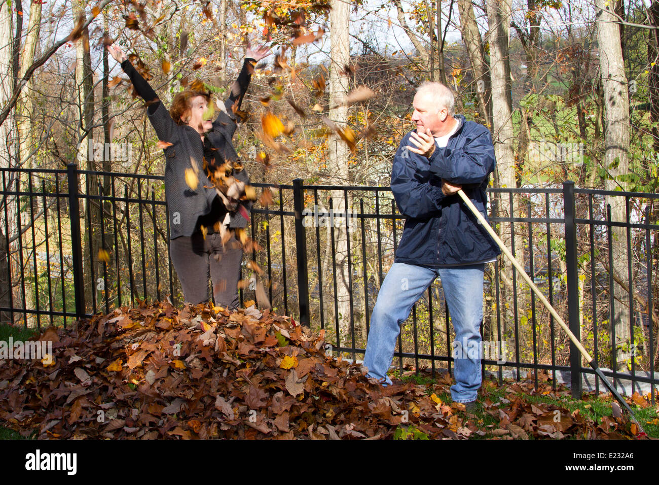 Man and woman playing in fall leaves Stock Photo - Alamy