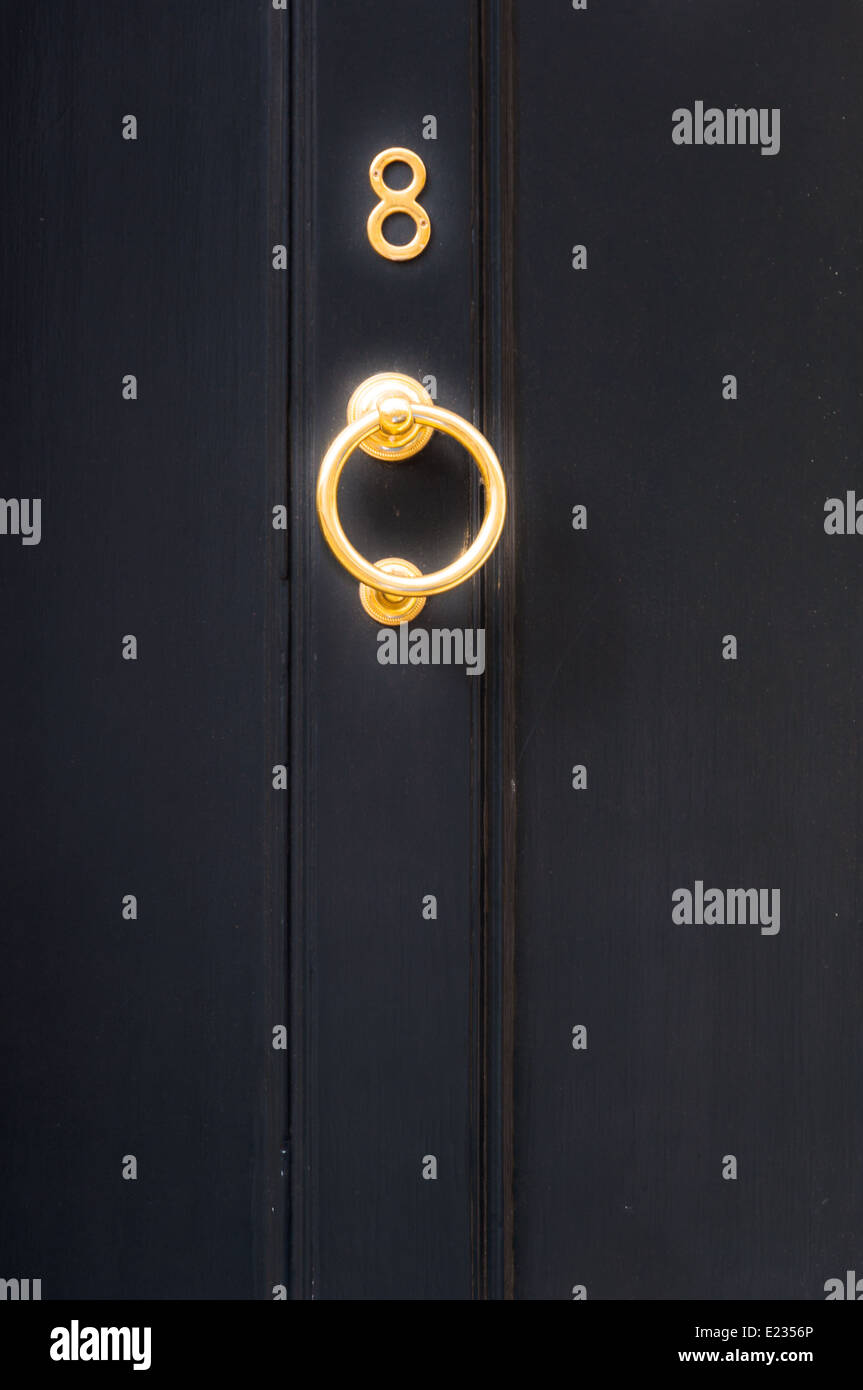 Number 8 and door knocker close up on a wooden door for use as a ...