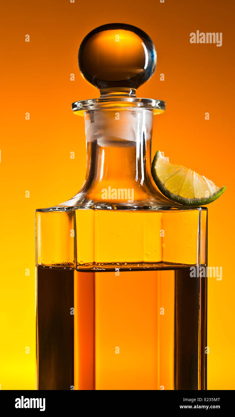 carafe with gold tequila and slice of lime Stock Photo - Alamy