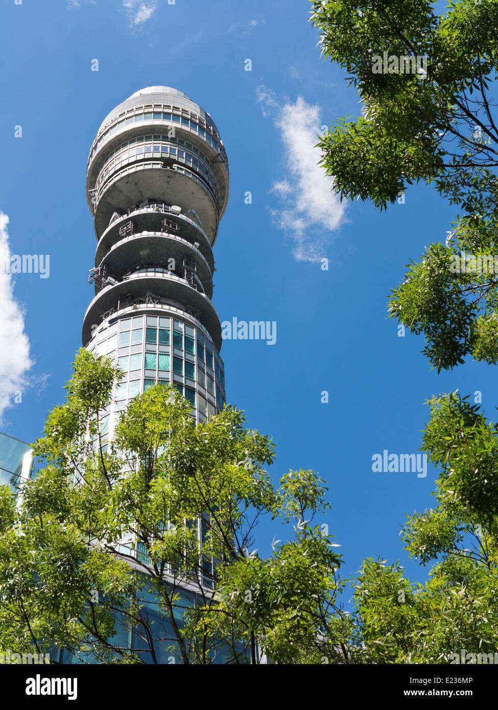 Telecom Tower against a blue sky with white clouds and trees Stock ...