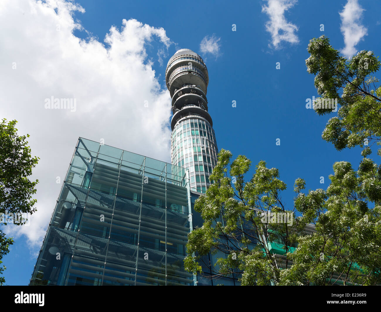 Telecom Tower against a blue sky with white clouds and trees Stock ...