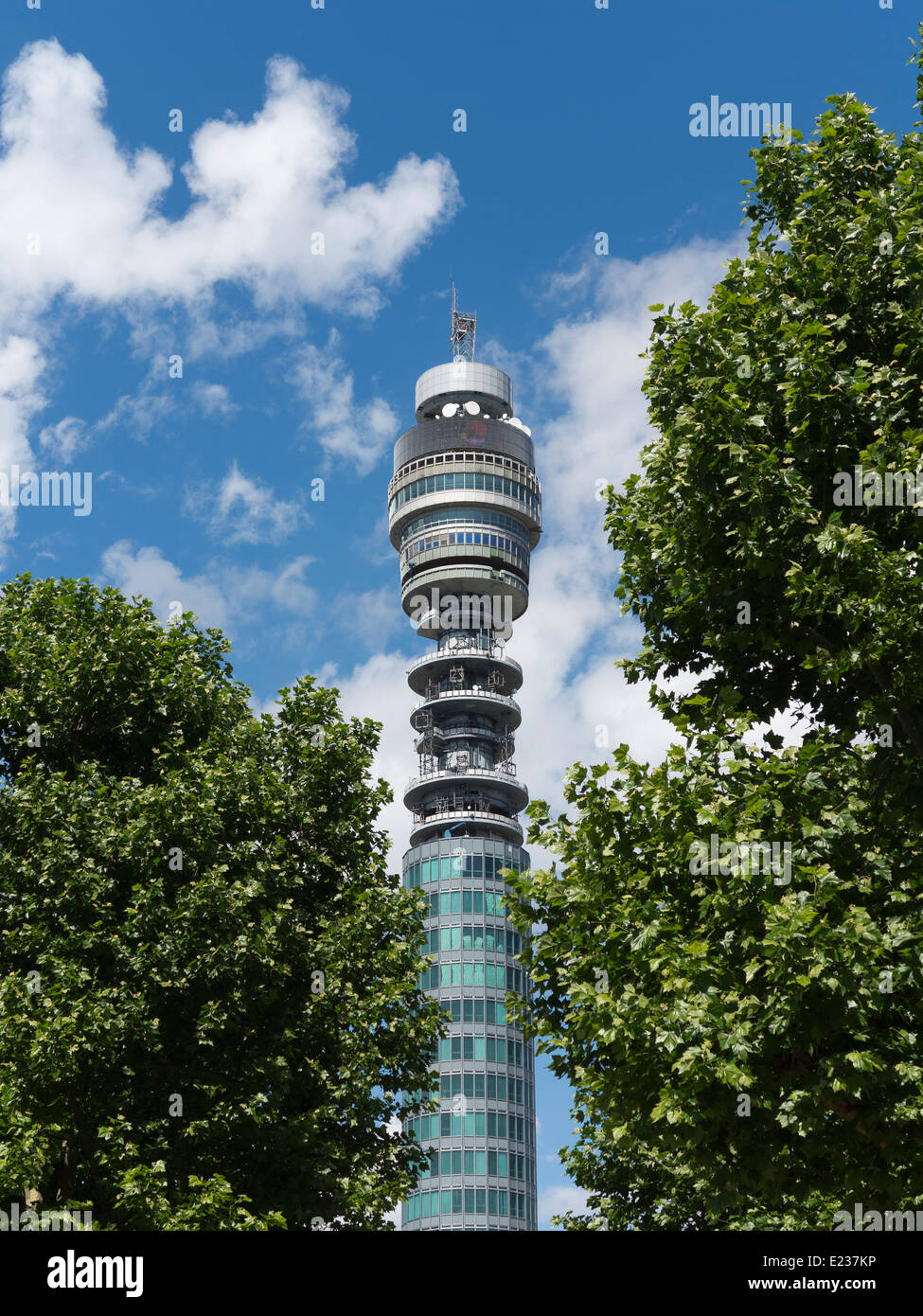 Telecom Tower against a blue sky with white clouds and trees Stock ...