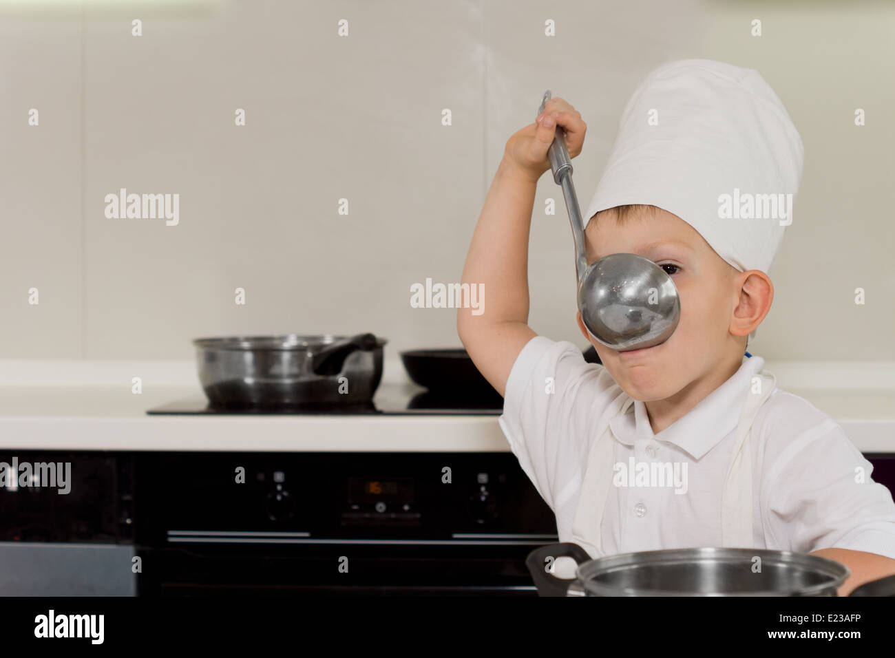 Young chef tasting soup from ladle in the kitchen Stock Photo - Alamy