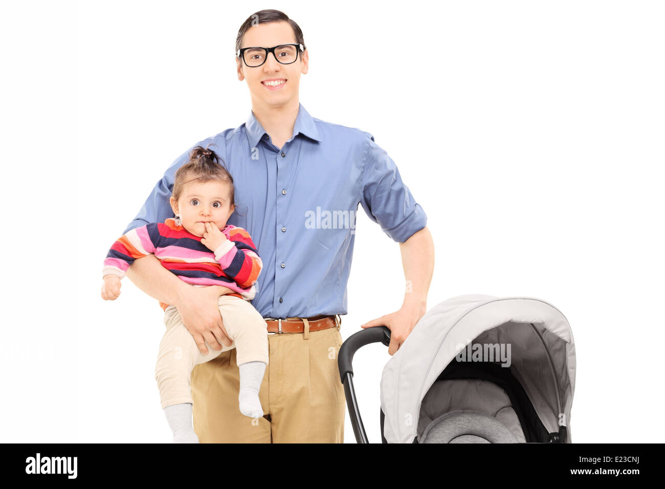 Young father holding his baby daughter and pushing a baby stroller ...