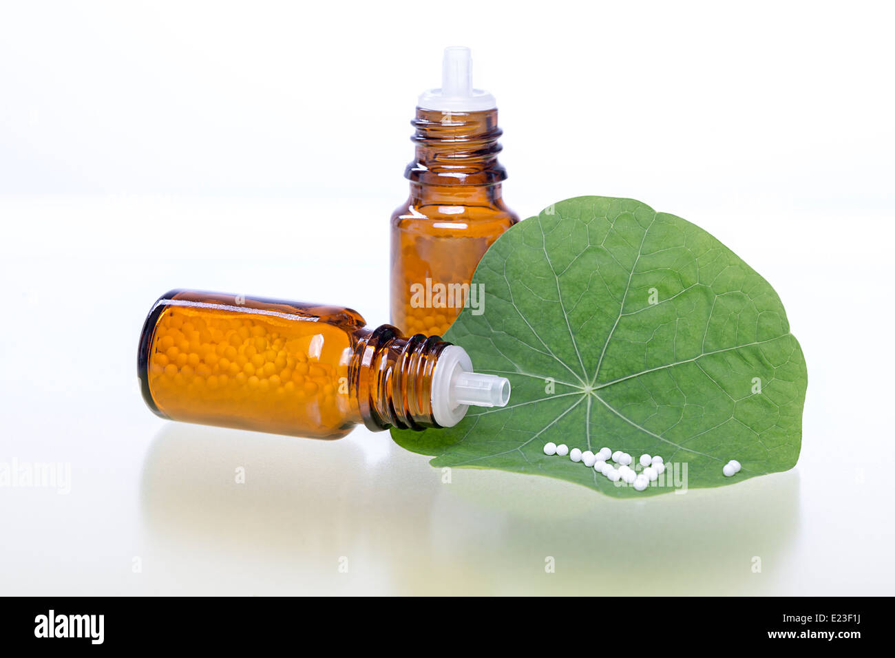 two bottles with homeopathy globules and green leaf Stock Photo - Alamy