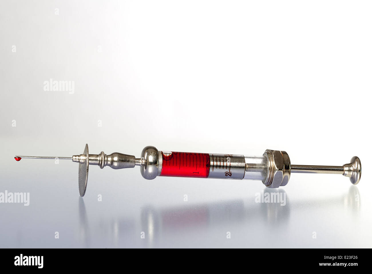 vintage syringe with blood on reflecting underground Stock Photo - Alamy