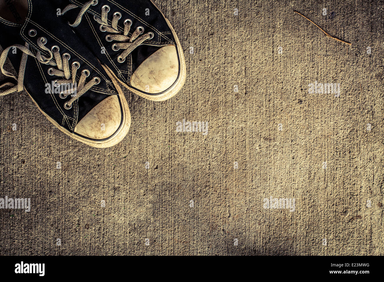 An old pair of trainers on a concrete background Stock Photo - Alamy
