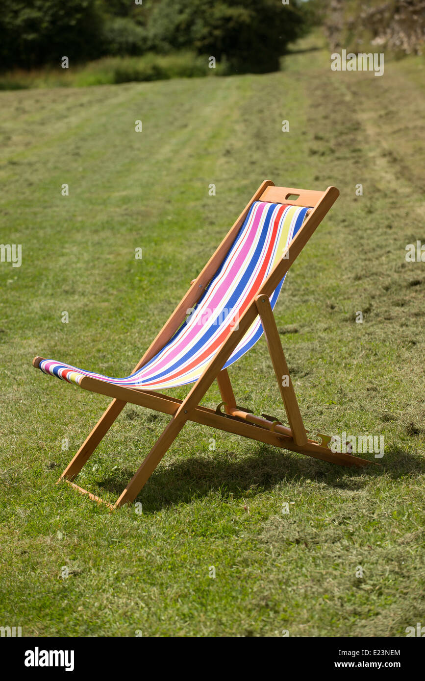 Colorful stripped deck chair open on the grass in countryside Stock ...