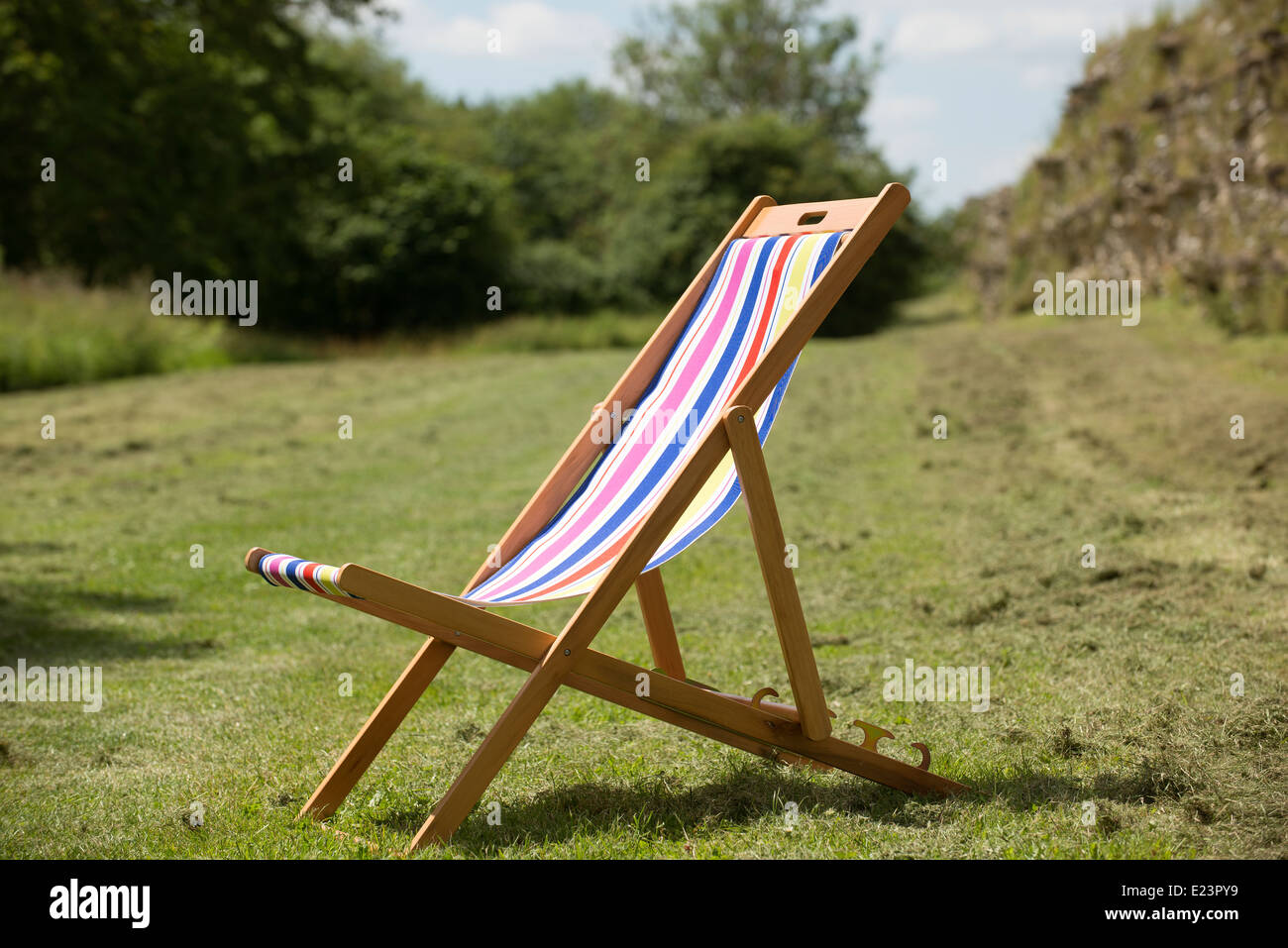 Colorful stripped deck chair open on the grass in countryside Stock ...