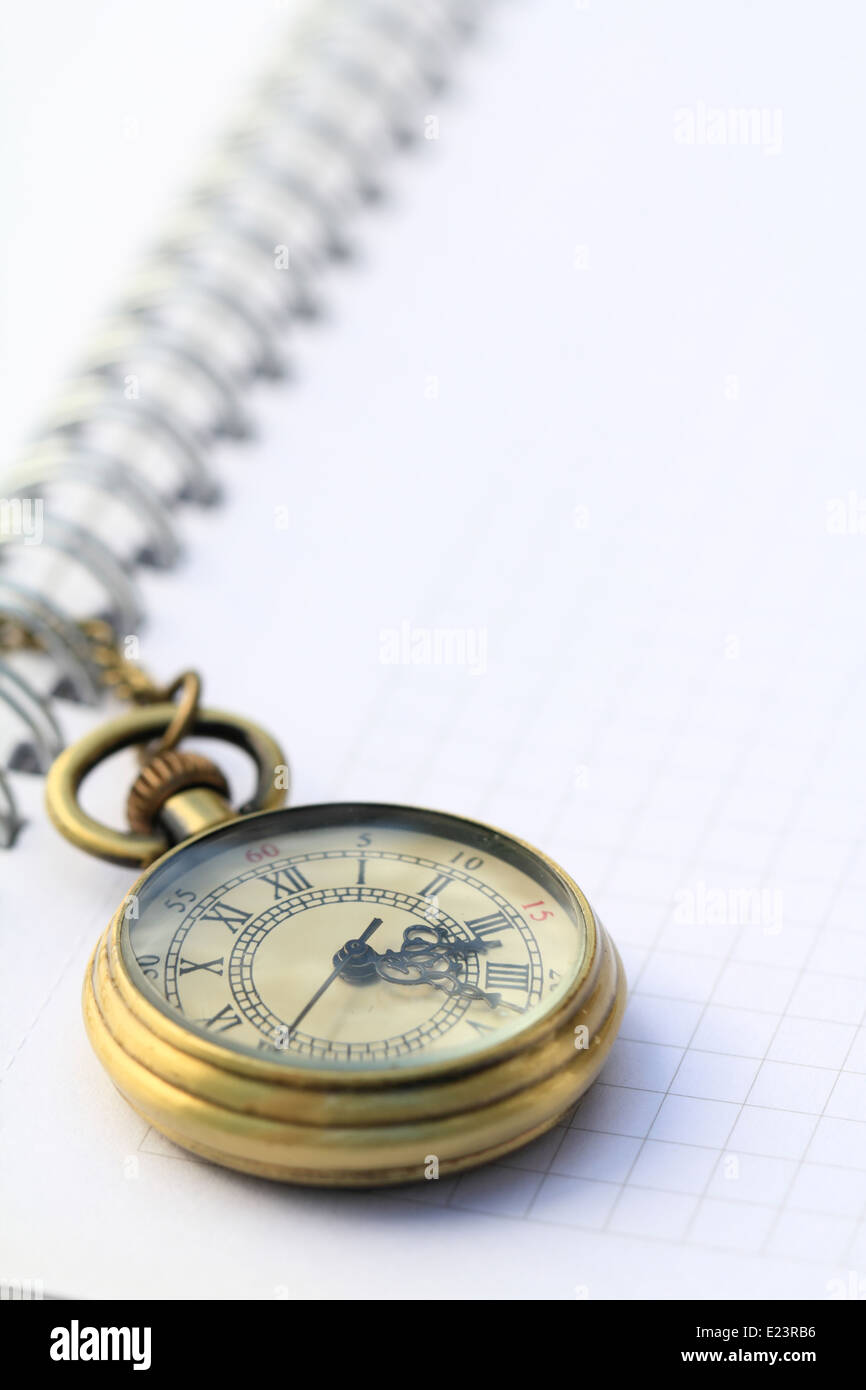 Pocket watch laying on a white notebook page Stock Photo - Alamy
