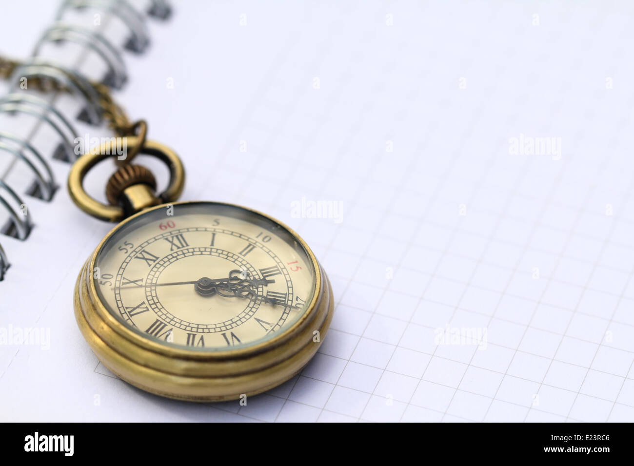 Pocket watch laying on a white notebook page Stock Photo - Alamy