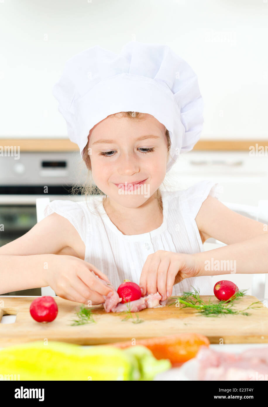 Little girl in chef hat cooking in kitchen Stock Photo - Alamy