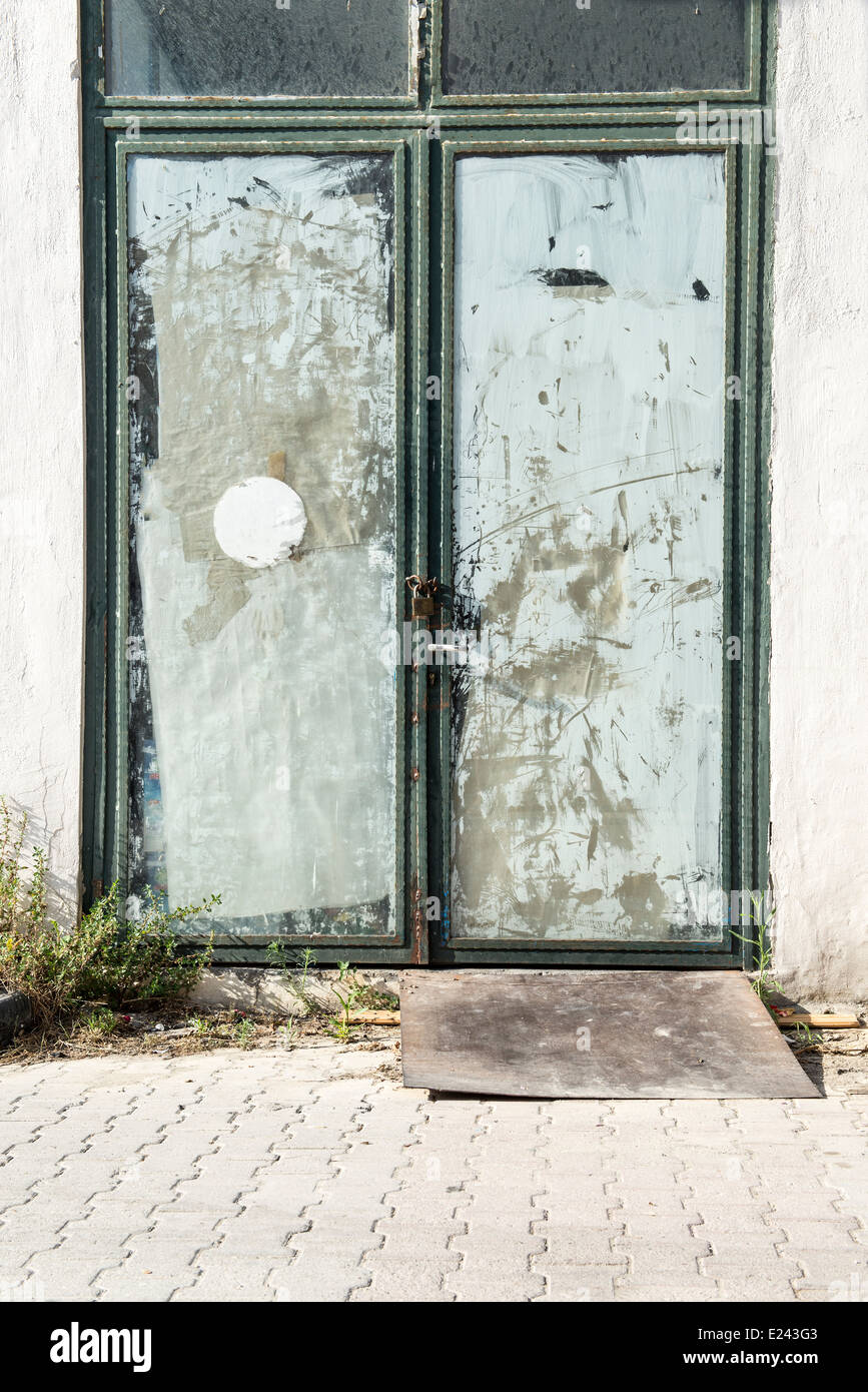 Old run down glass shop door padlocked and colosed Stock Photo - Alamy