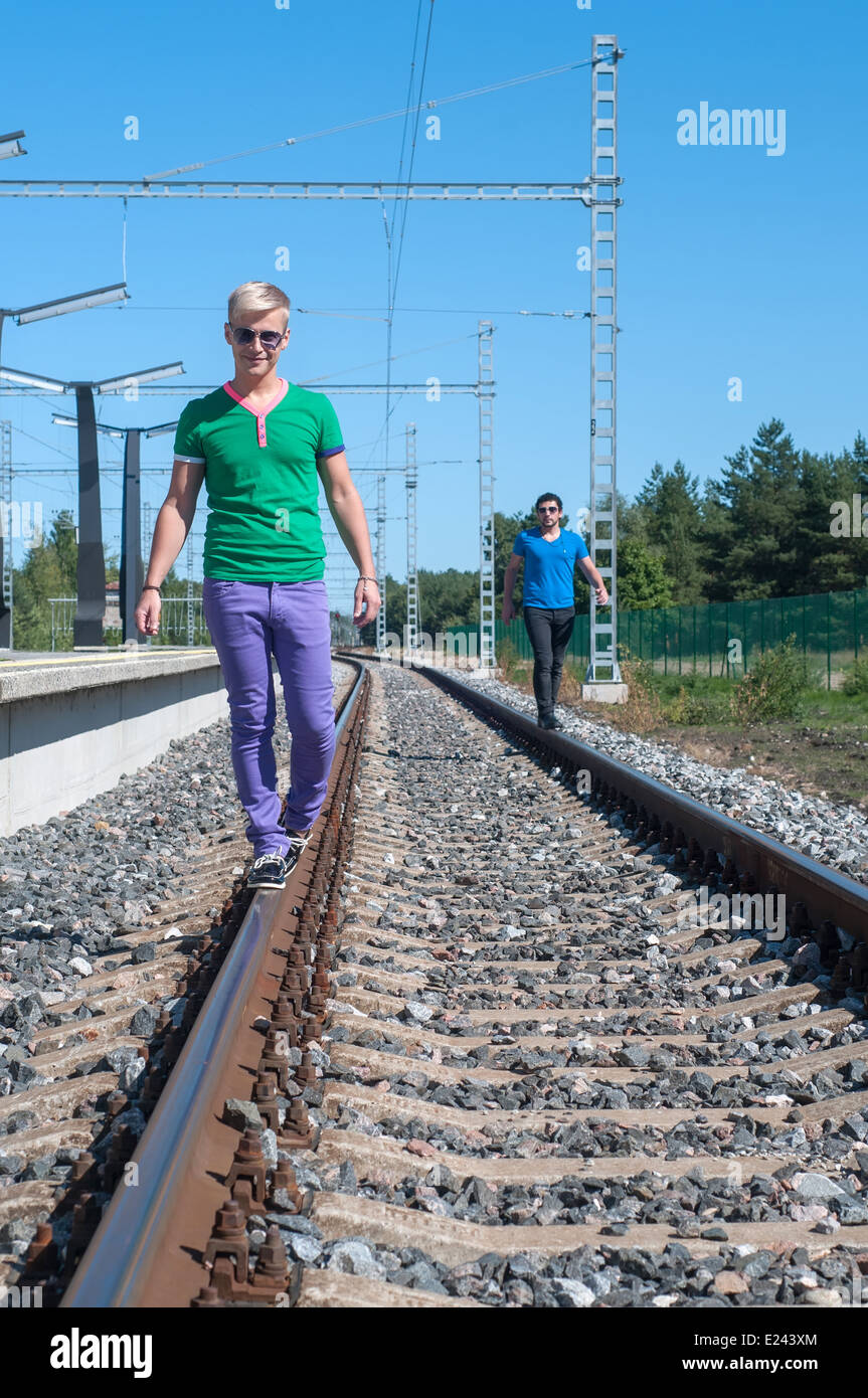 Two young men walking on the rail track Stock Photo - Alamy