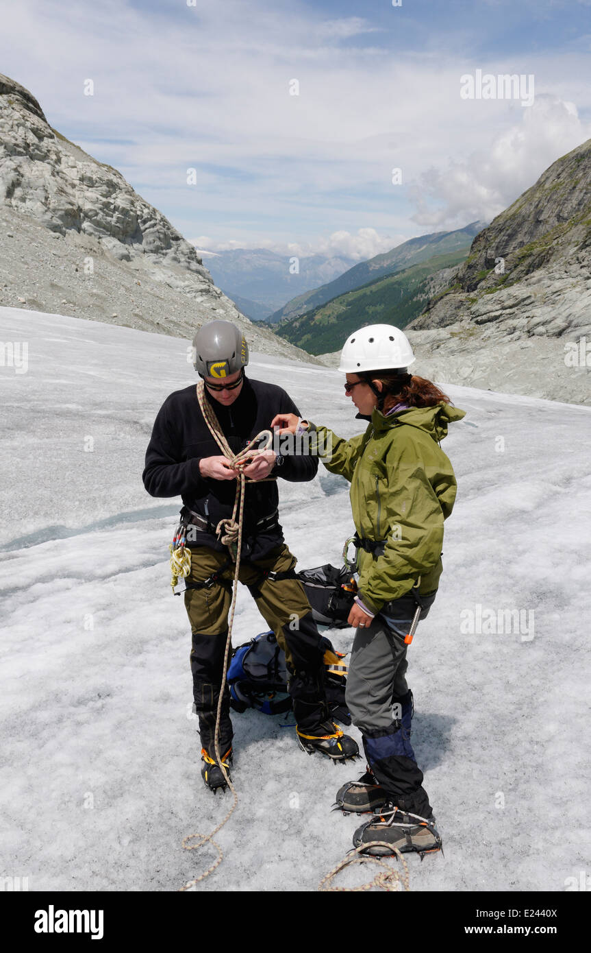 A lady mountaineer practicing tying knots in a climbing rope on an ...