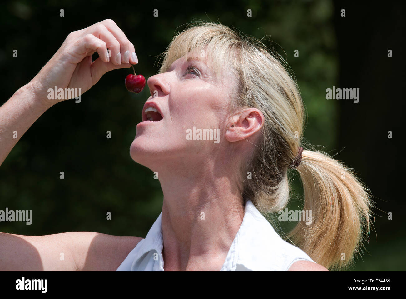 Woman eating cherries Stock Photo - Alamy