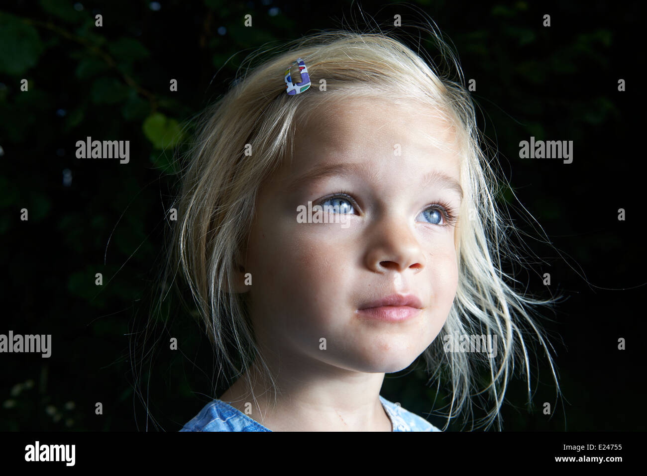 Portrait of Child Little blond girl in yard, outside in summer garden ...