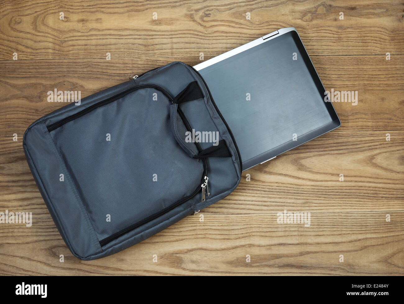 Overhead tilted view of laptop computer and carry case, on rustic ...