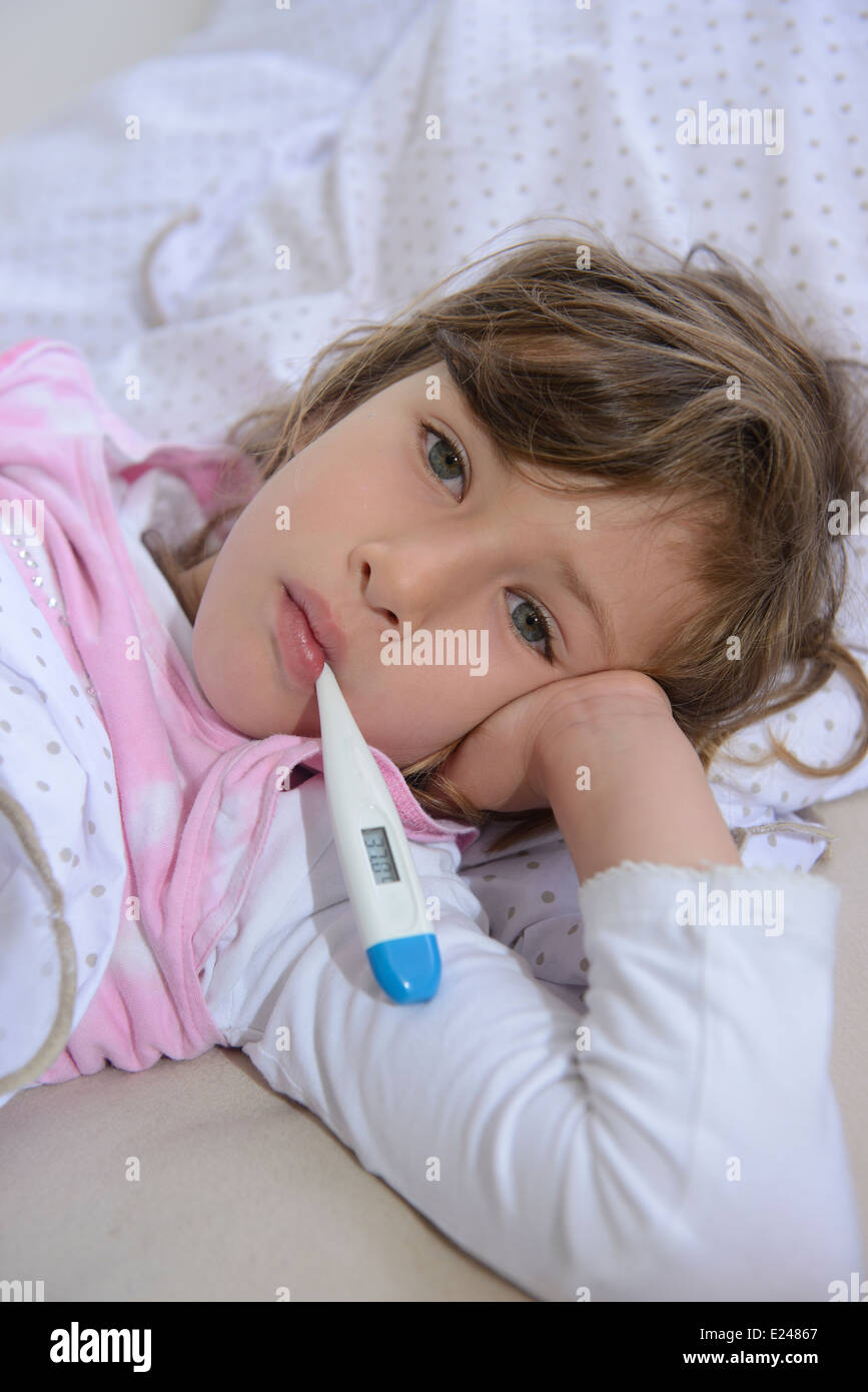 Sick child with fever in bed Stock Photo - Alamy