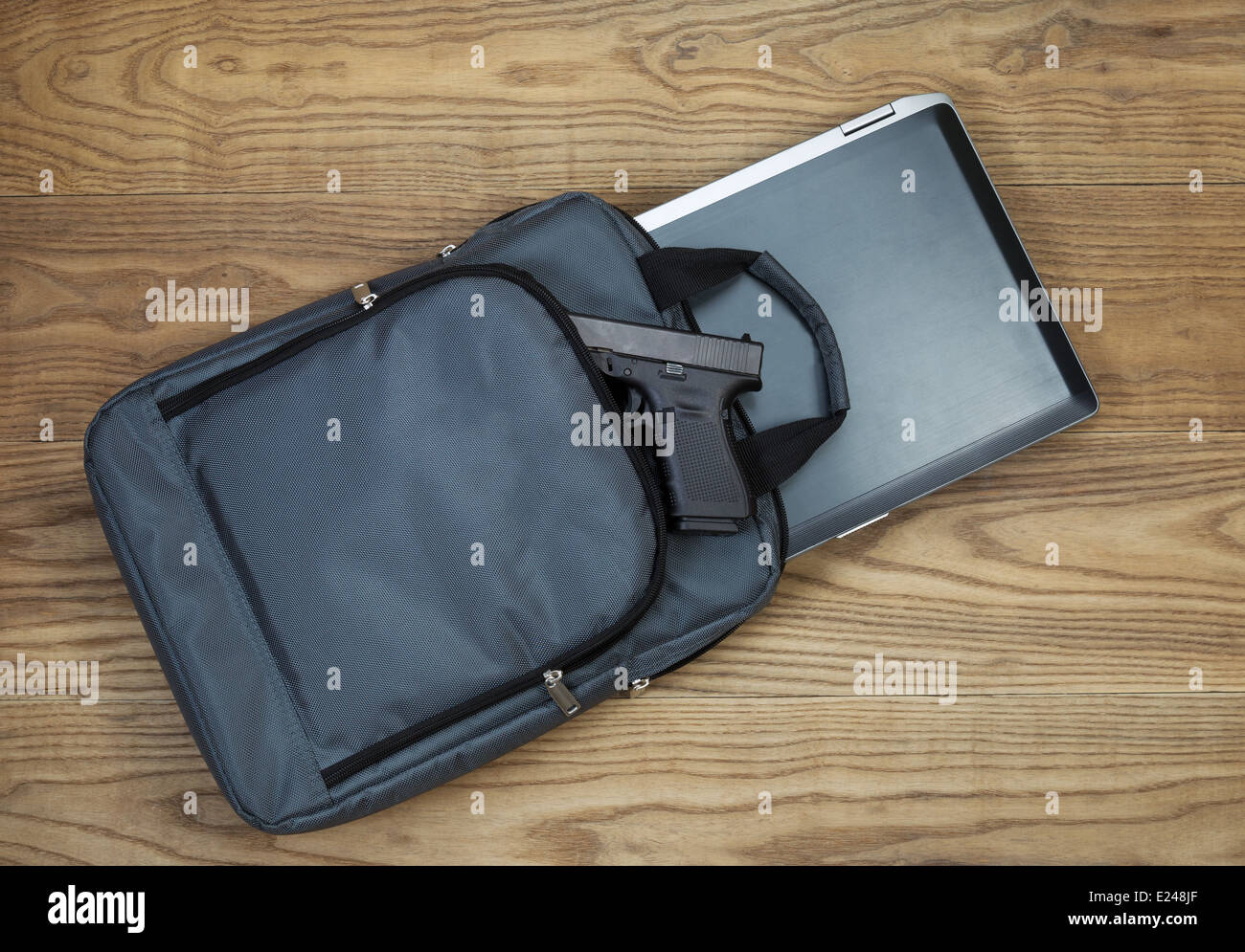 Overhead tilted view of laptop computer, personal weapon and carry case ...