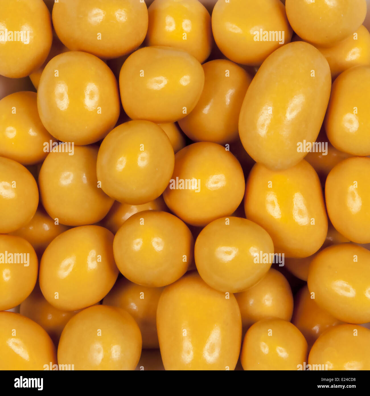 a background of peanuts covered with orange chocolate Stock Photo - Alamy