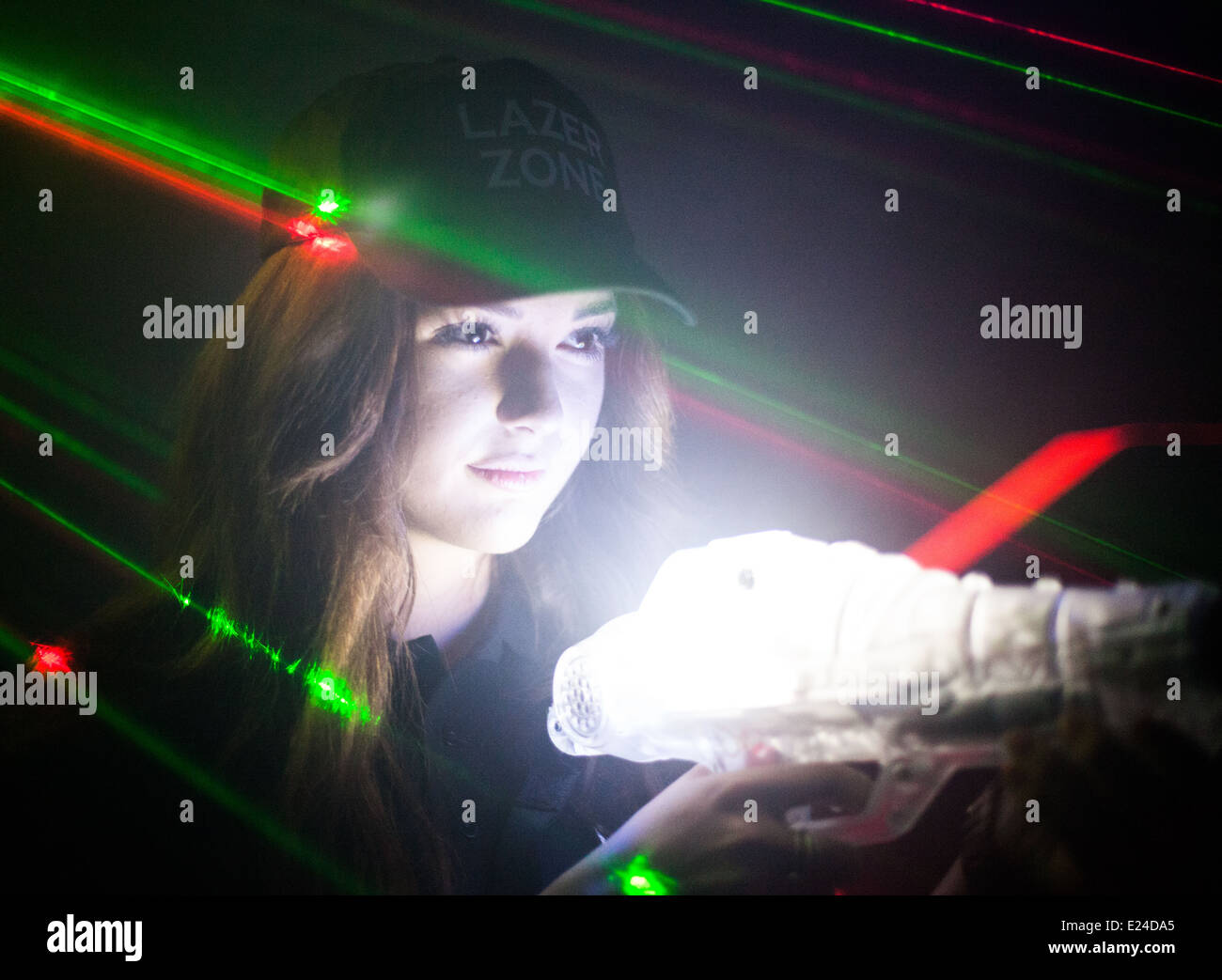 a pretty female model playing a laser / lazer gun war game in a special ...