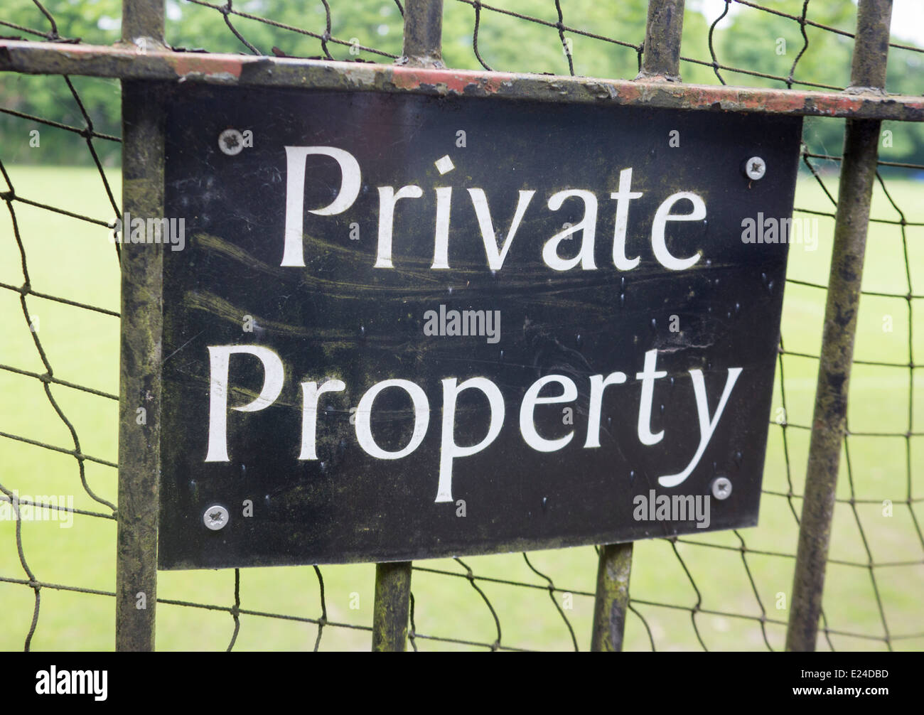 'Private Property' sign on metal railings with netting behind London ...