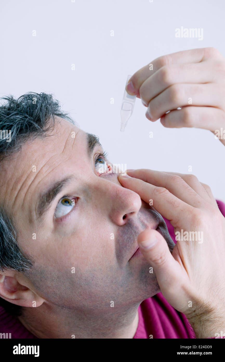 Man using eye lotion Stock Photo - Alamy