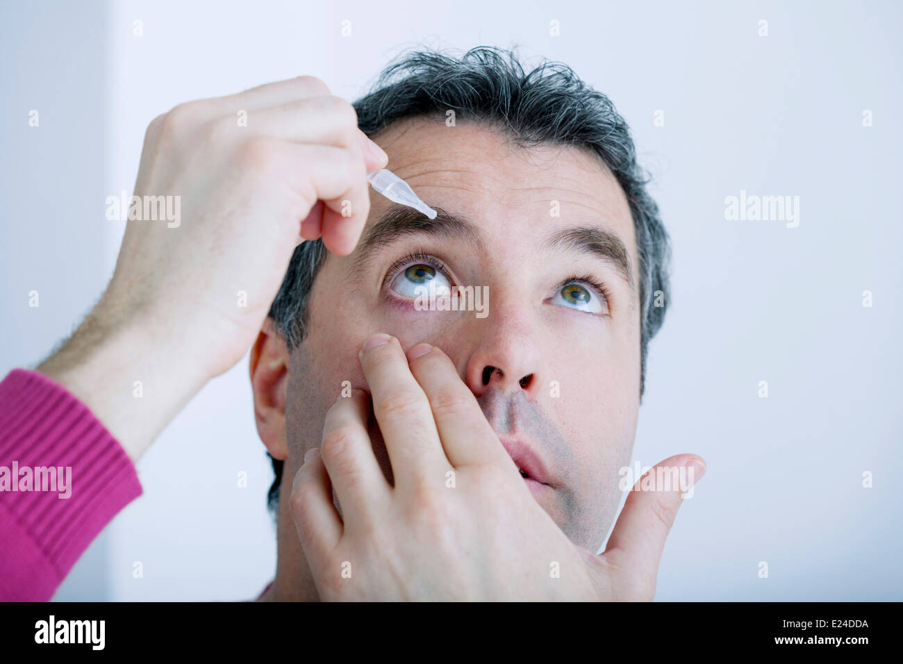 Man using eye lotion Stock Photo - Alamy