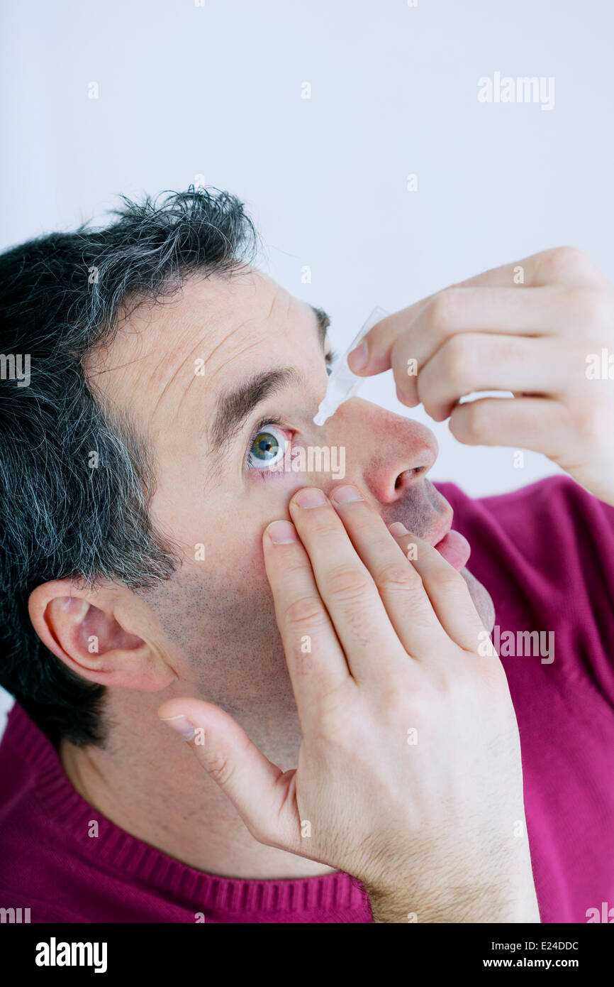 Man using eye lotion Stock Photo - Alamy