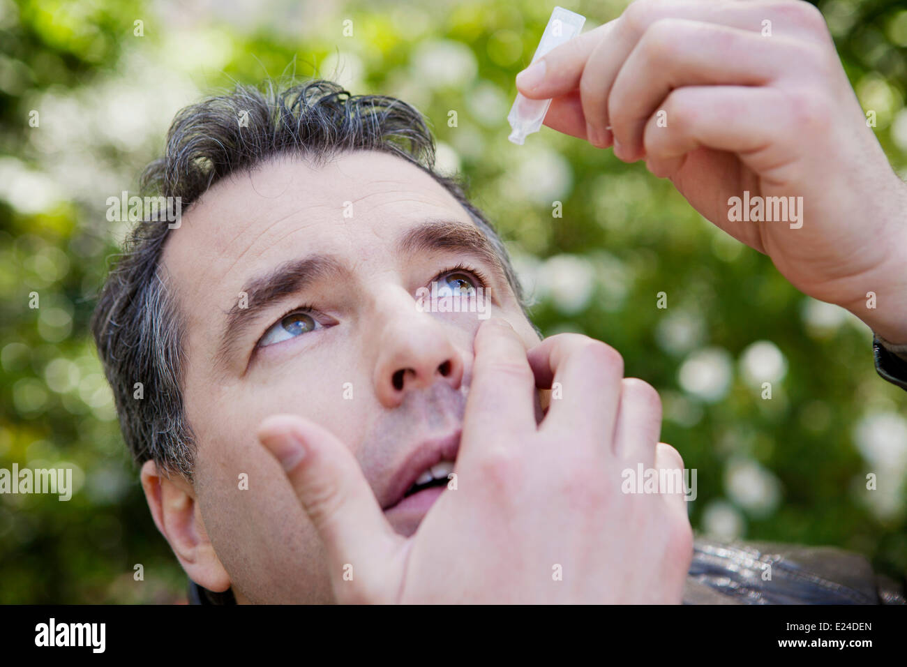 Man using eye lotion Stock Photo - Alamy