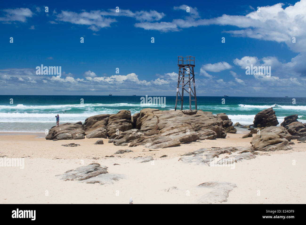 Redhead Beach with old lifeguard tower on rocks and coal loading ships ...