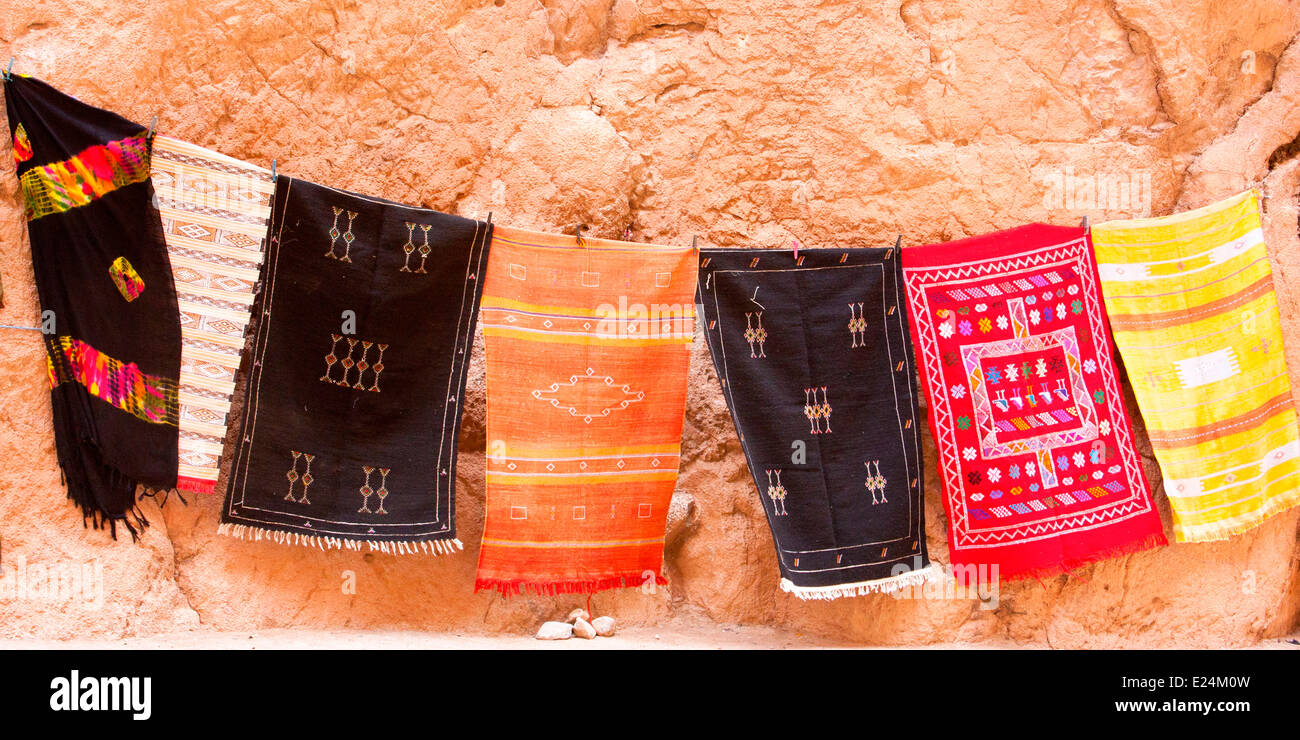 Colourful Moroccan textiles hang on the cliff walls of the Tordra Gorge ...