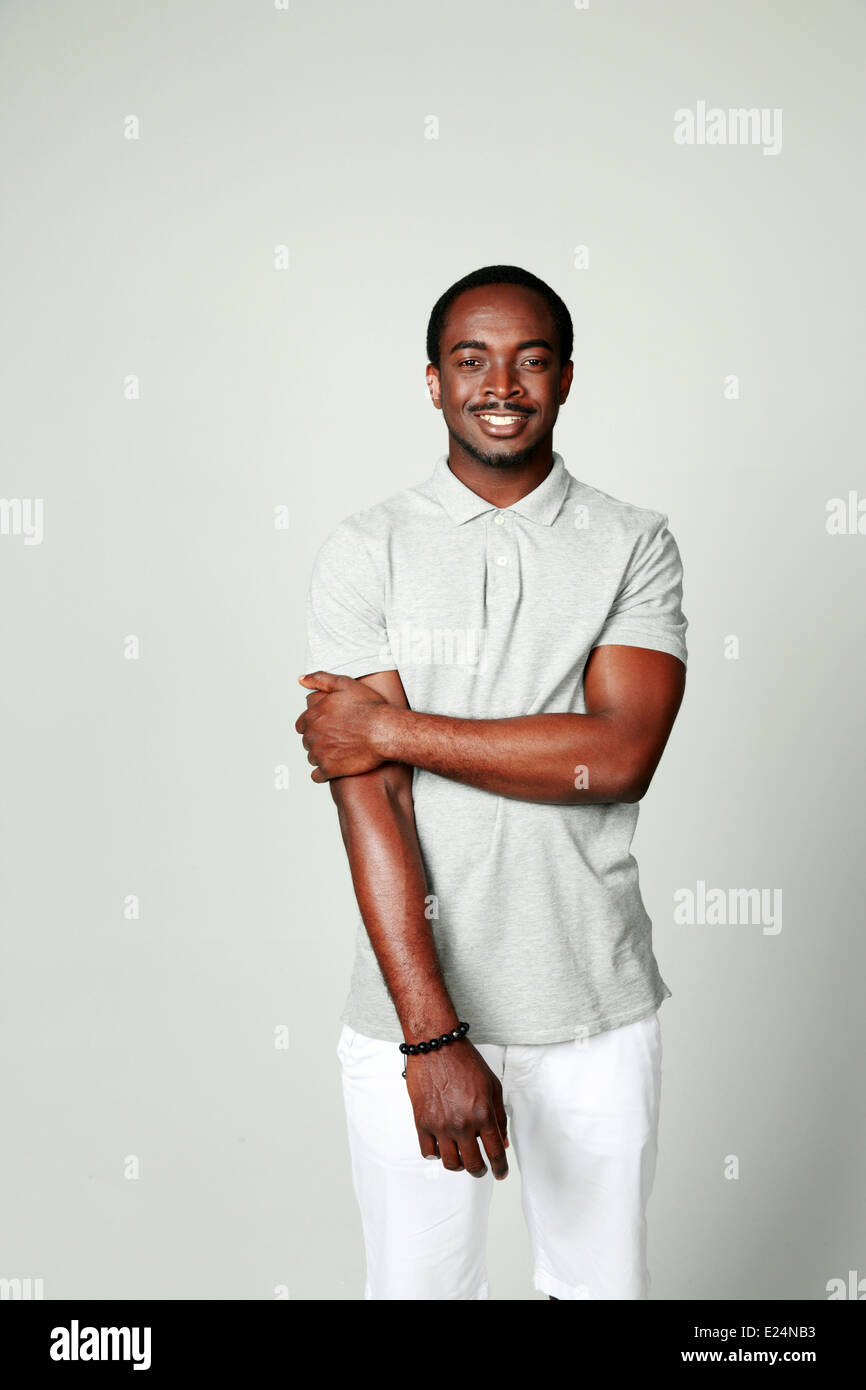 Happy african man standing on gray background Stock Photo - Alamy